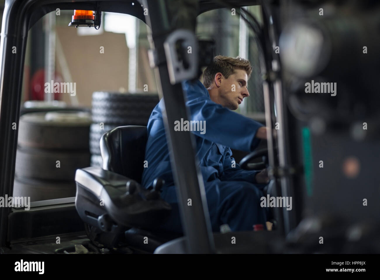 Factory working driving a fork lift in warehouse Stock Photo - Alamy