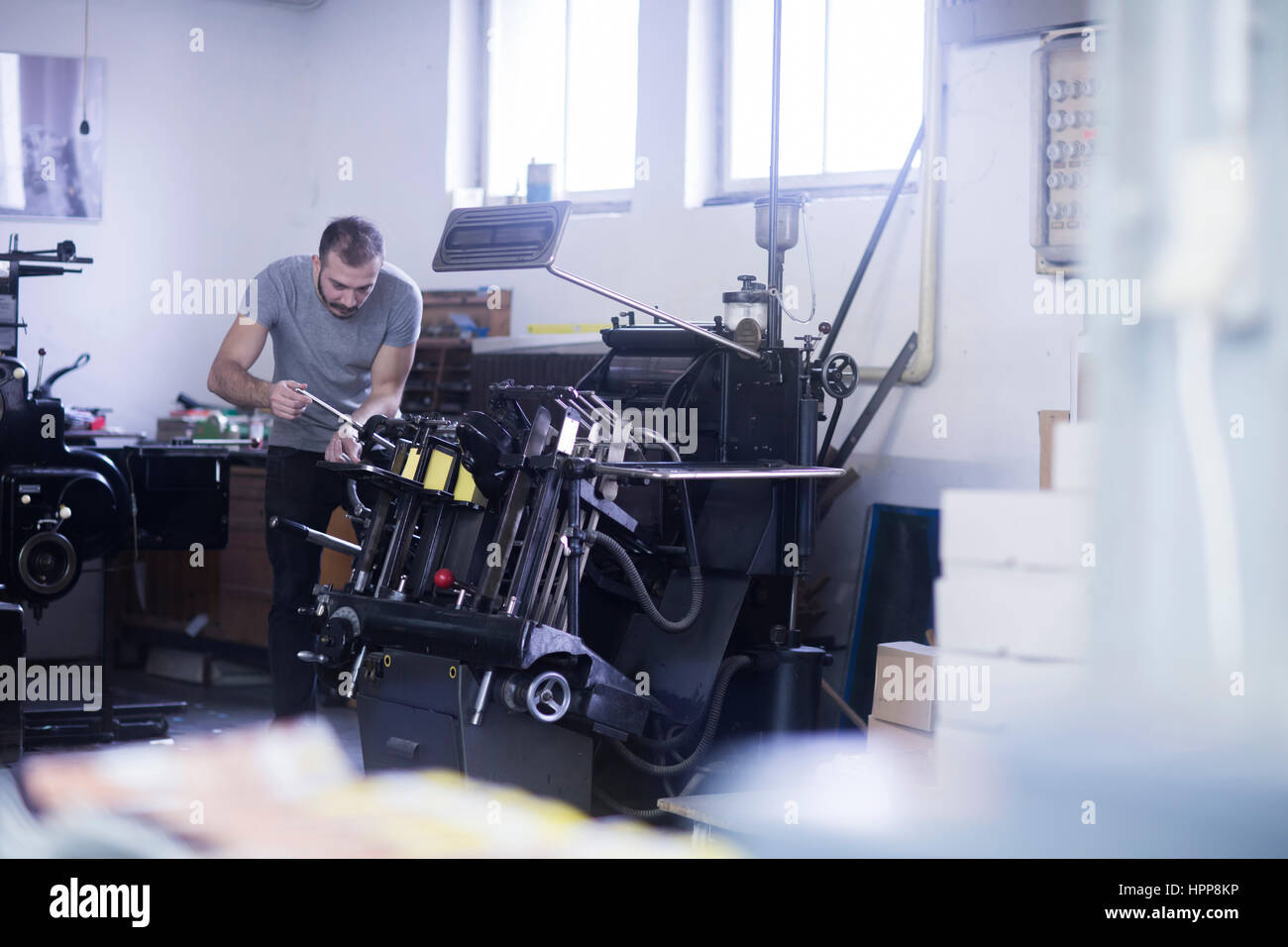 Young man working in printing shop Stock Photo - Alamy