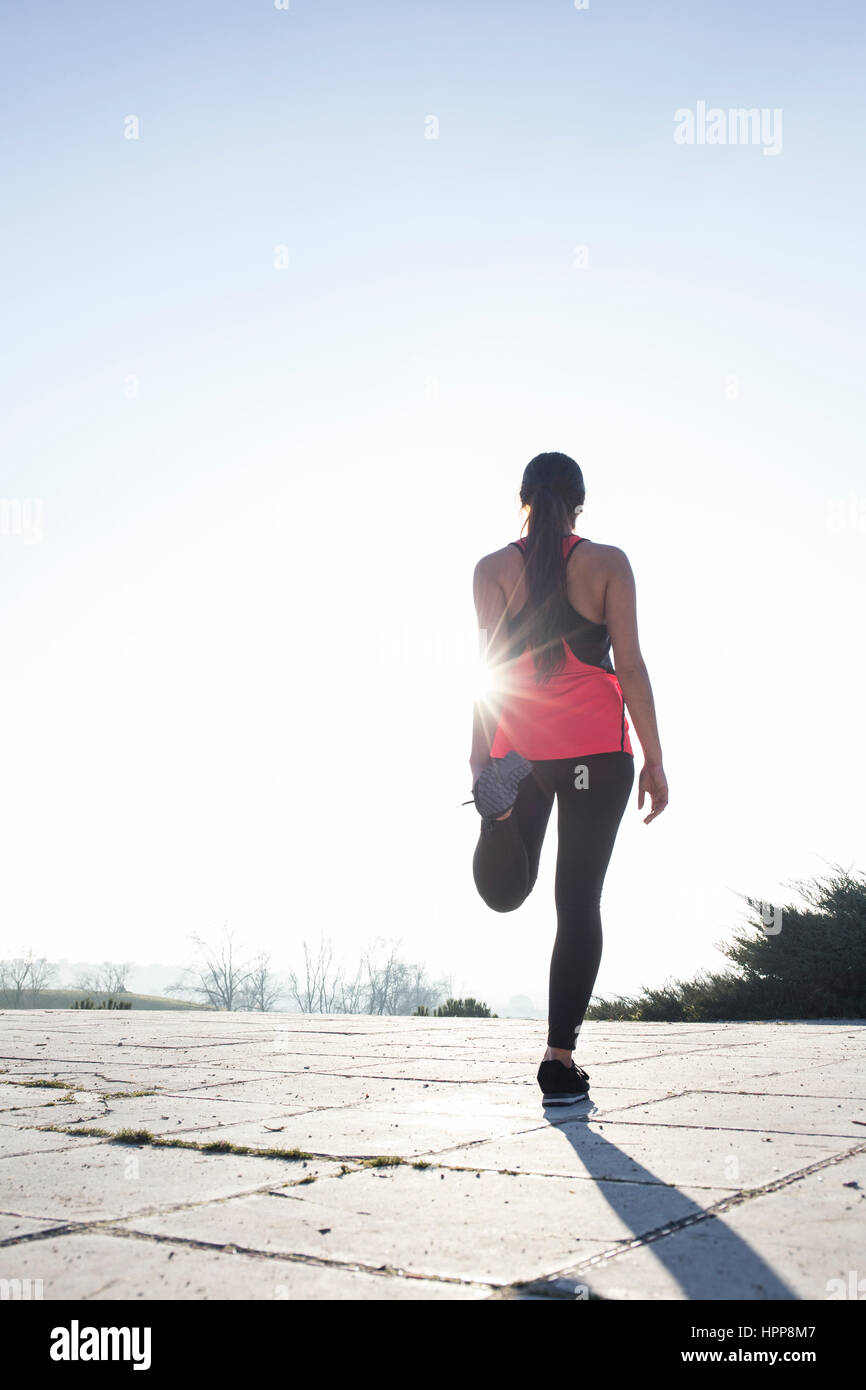 Young woman stretching before running Stock Photo - Alamy