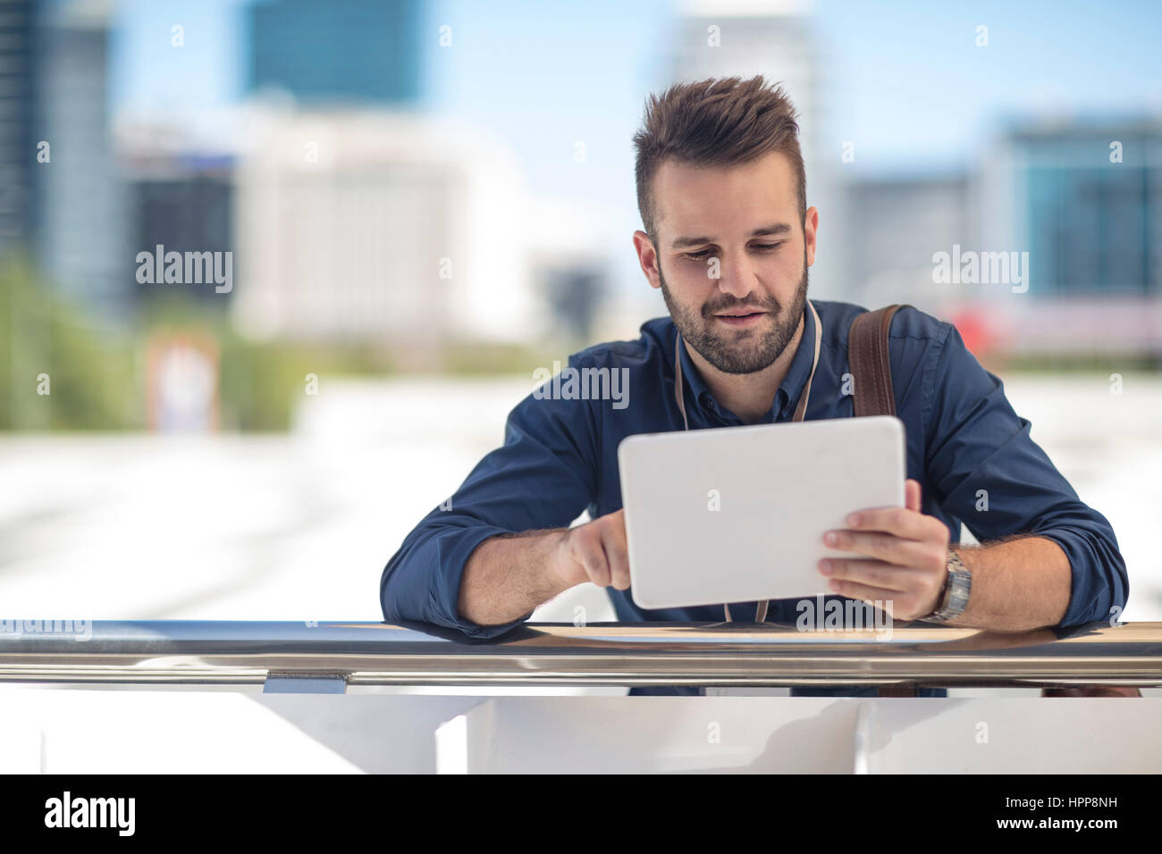Young man using tablet outdoors Stock Photo - Alamy