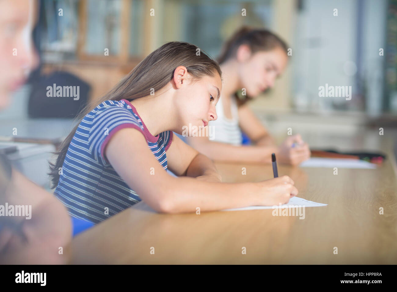 Female students writing during class test Stock Photo - Alamy