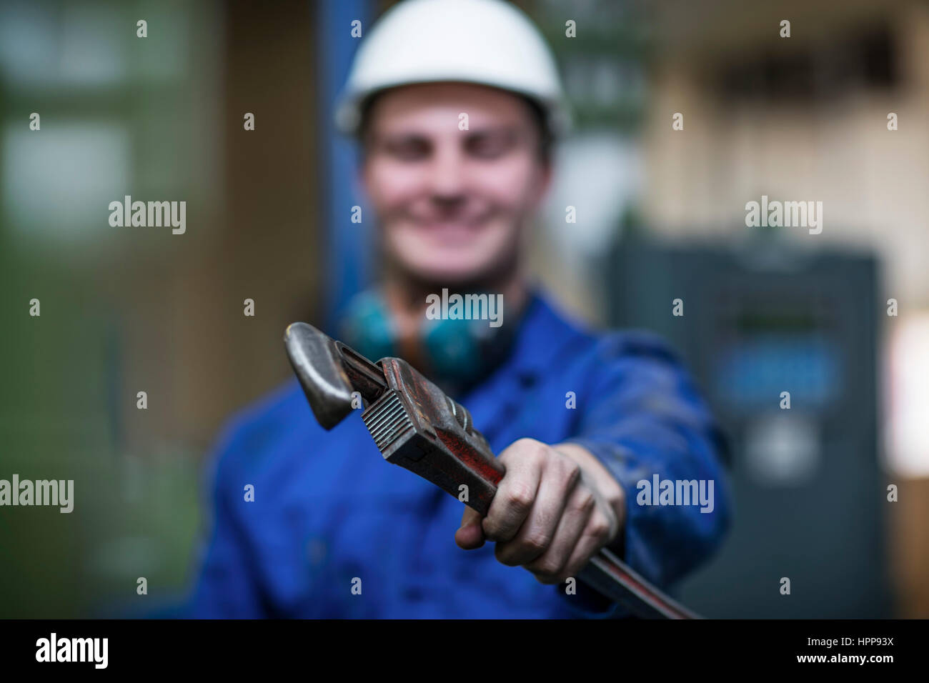 Worker in factory holding wrench tool Stock Photo - Alamy