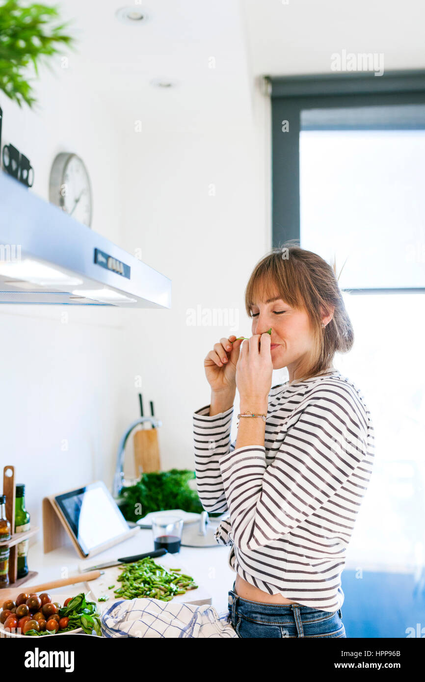 Young woman cooking vegan pasta in her kitchen Stock Photo - Alamy