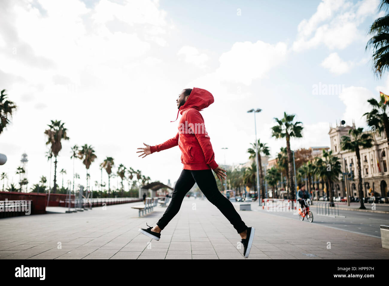 Young man in the city jumping on pavement Stock Photo - Alamy