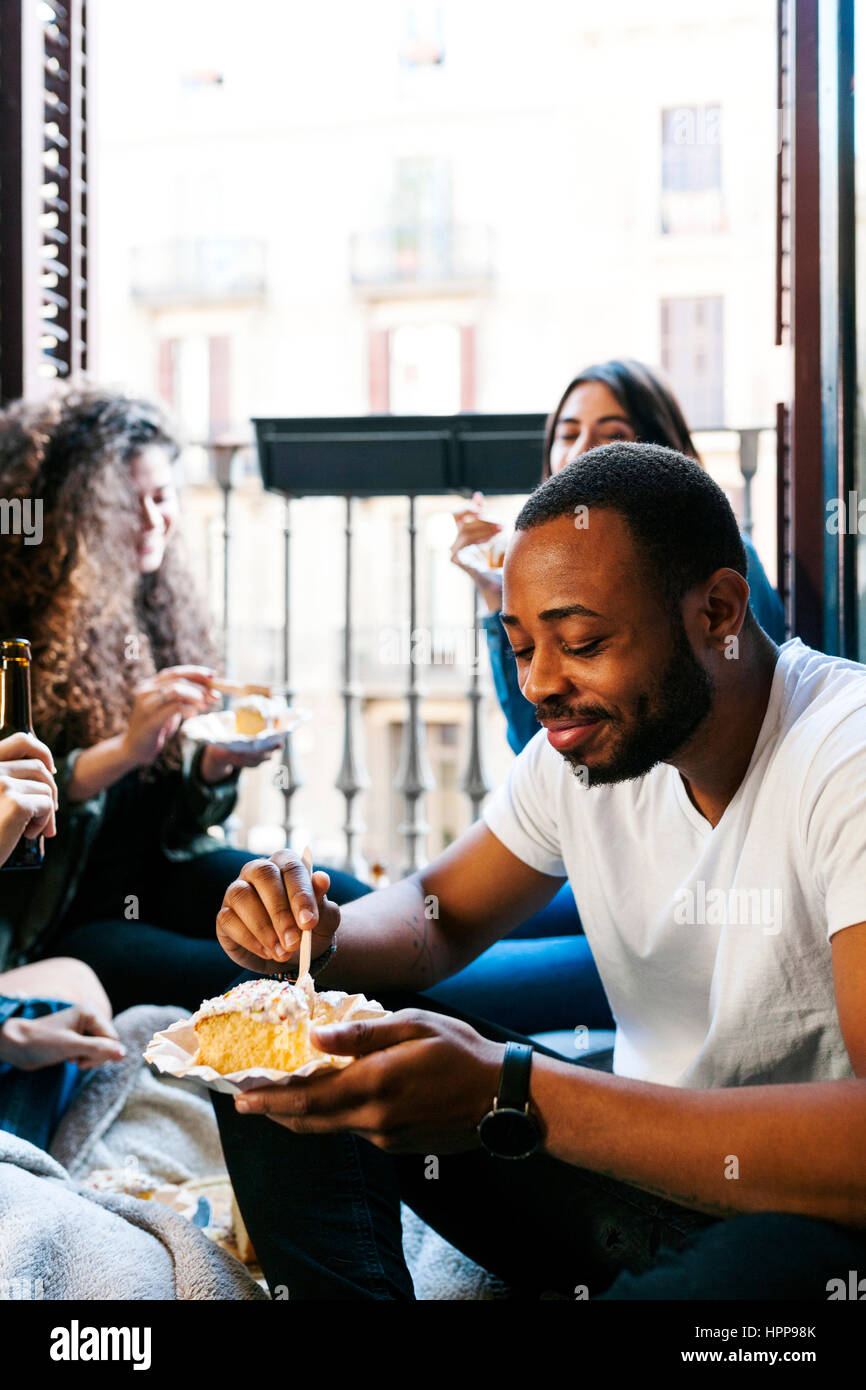 Group of friends sitting on the floor at home eating birthday cake ...