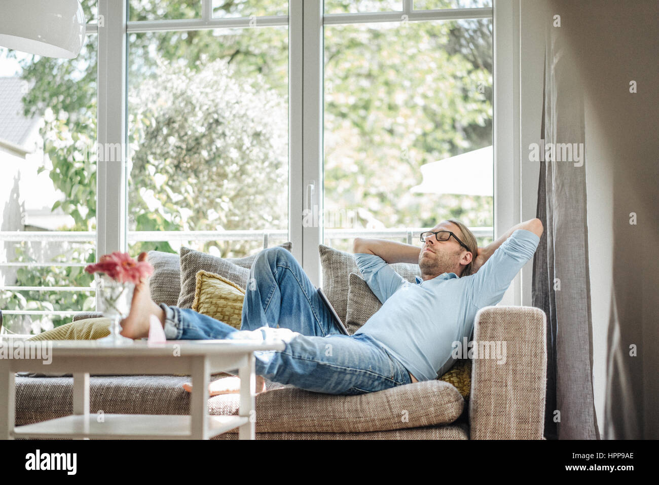Man relaxing on couch Stock Photo - Alamy