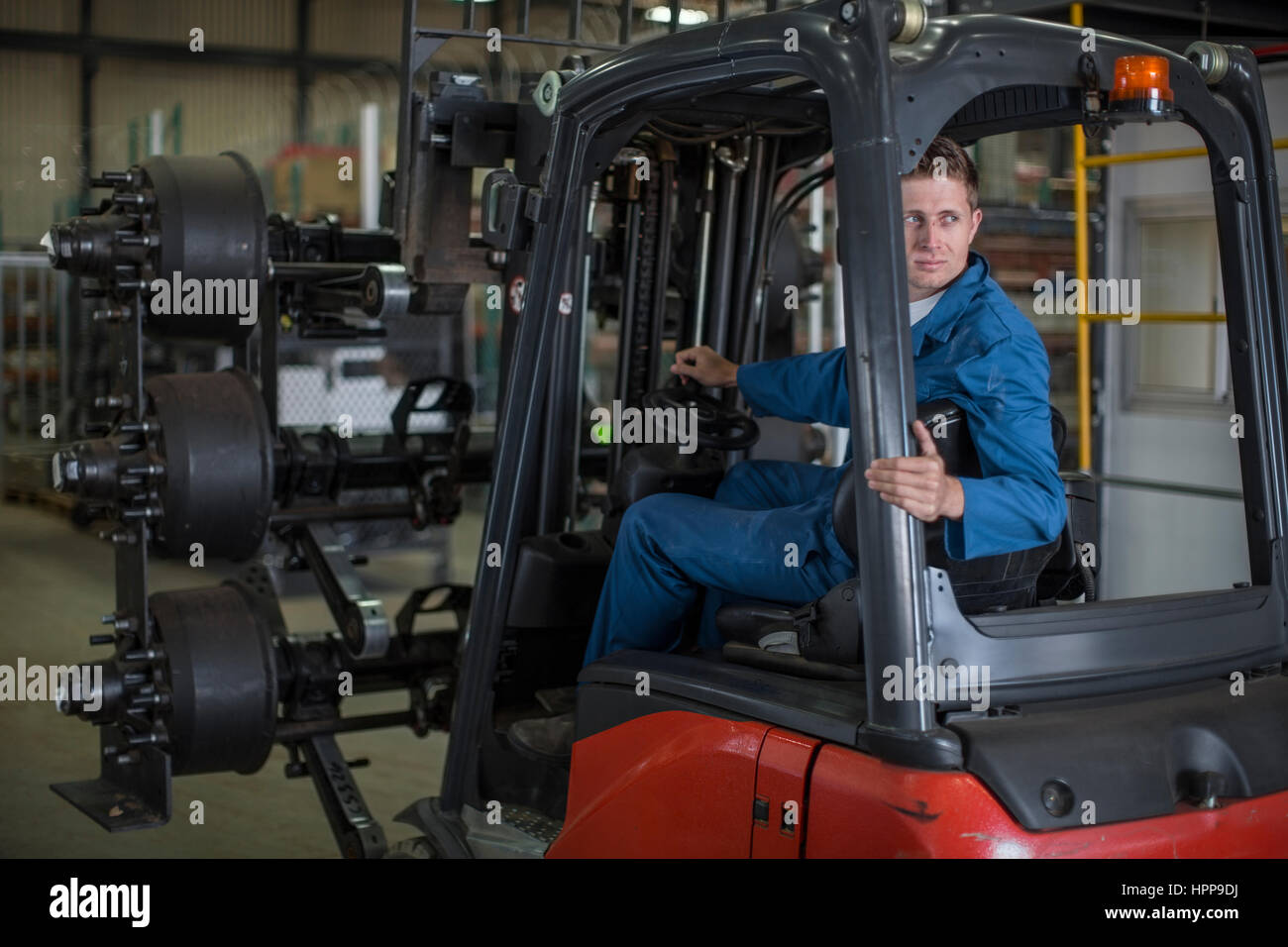 Factory working driving a fork lift in warehouse Stock Photo - Alamy
