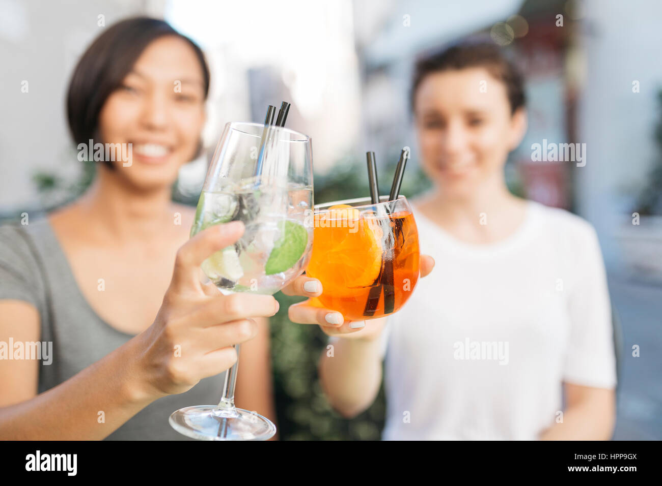 Two young women toasting with cocktails, close-up Stock Photo - Alamy
