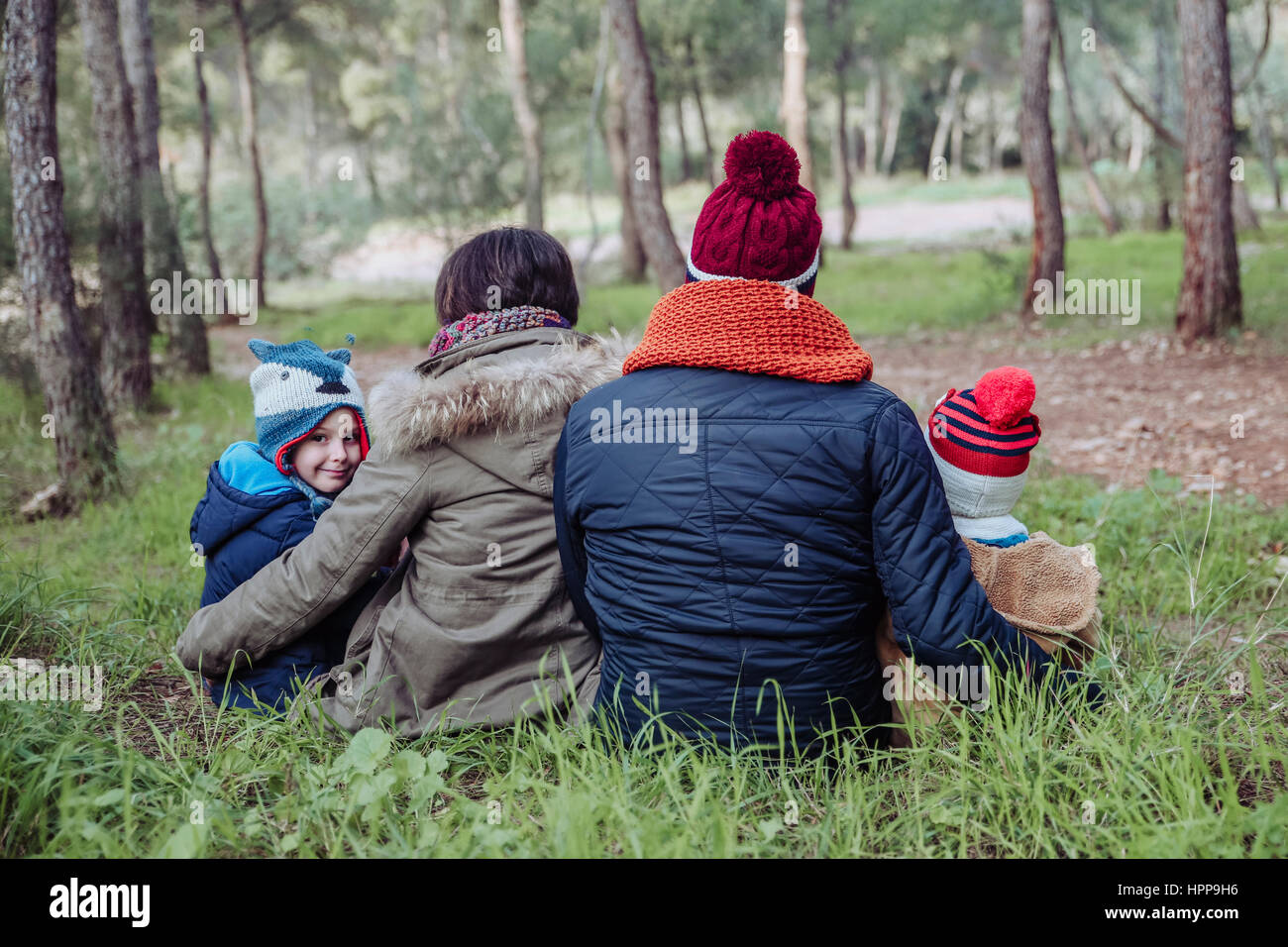 Rear view of family sitting in forest Stock Photo - Alamy
