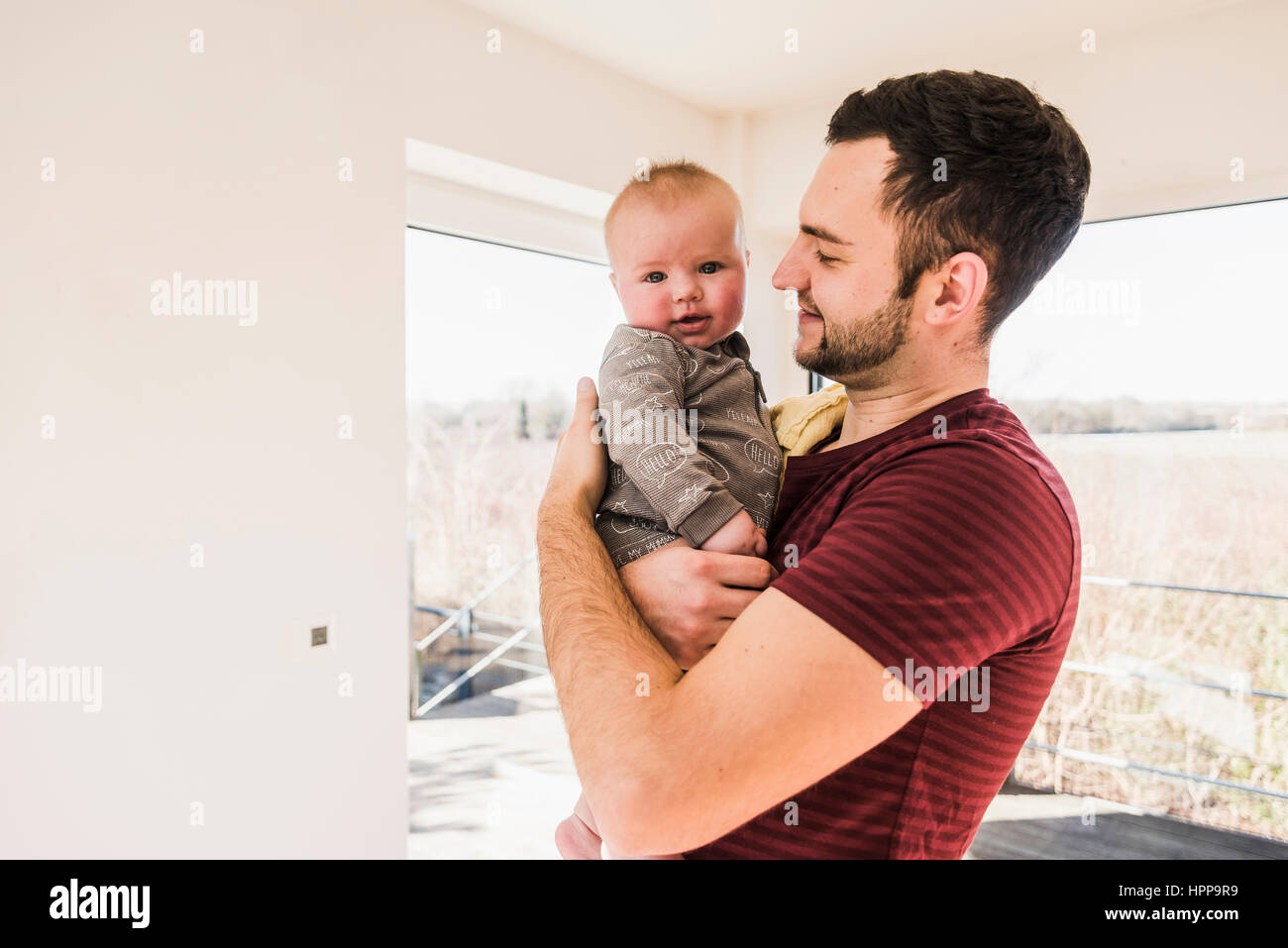 Father holding baby son in his arms Stock Photo - Alamy