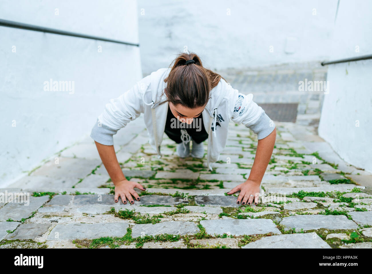 Young woman doing push ups in the street Stock Photo - Alamy