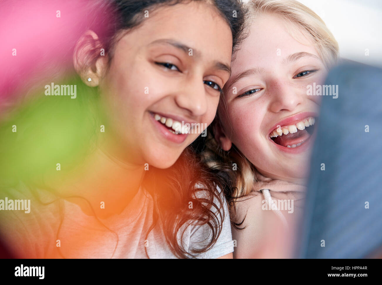 Two laughing girls looking smartphone hi-res stock photography and images - Alamy