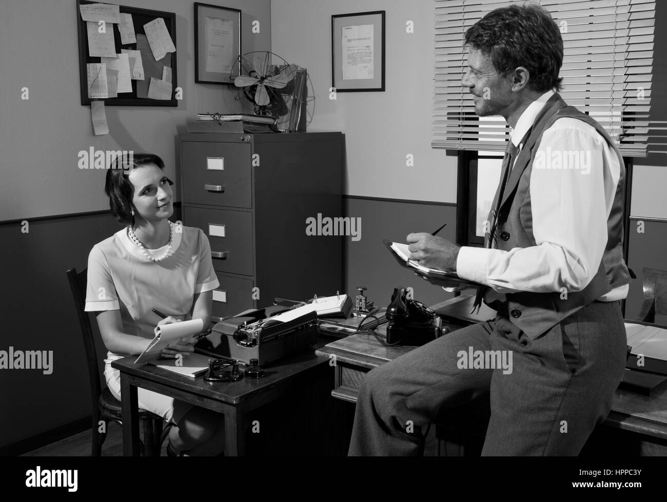 Vintage director and female secretary working together in 1950s style ...
