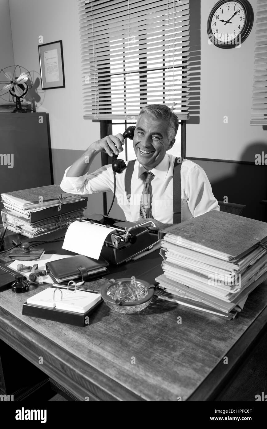 Vintage professional journalist on the phone working at office desk ...