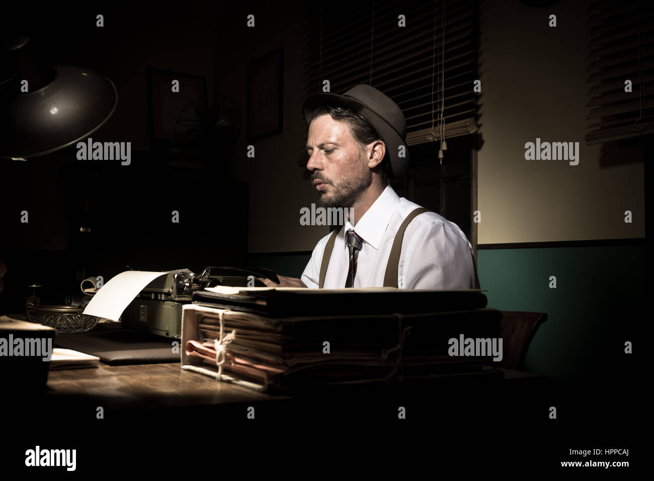 Vintage reporter working late at night typing on typewriter Stock Photo ...