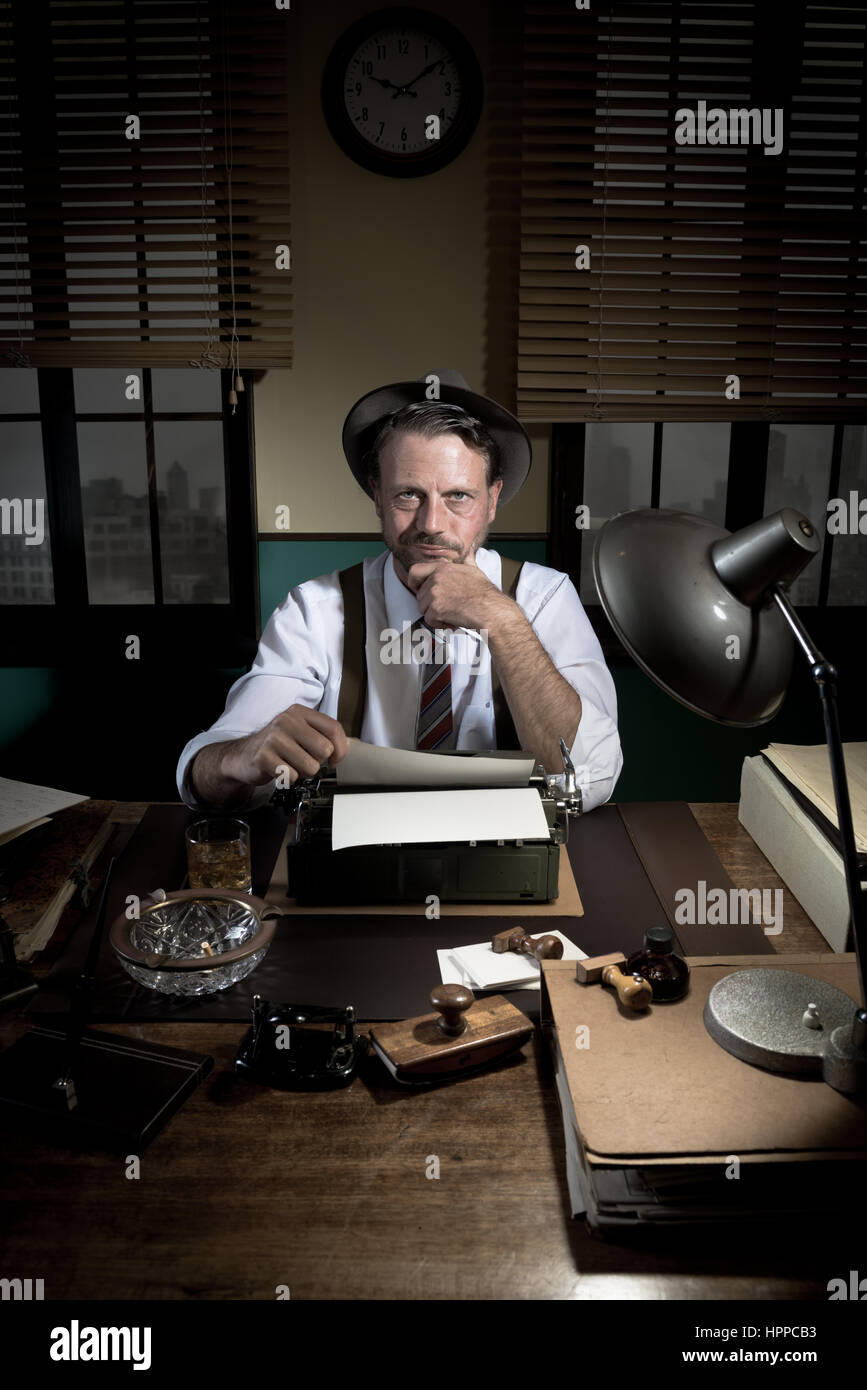 Smiling talented reporter typing on a typewriter in his office Stock ...