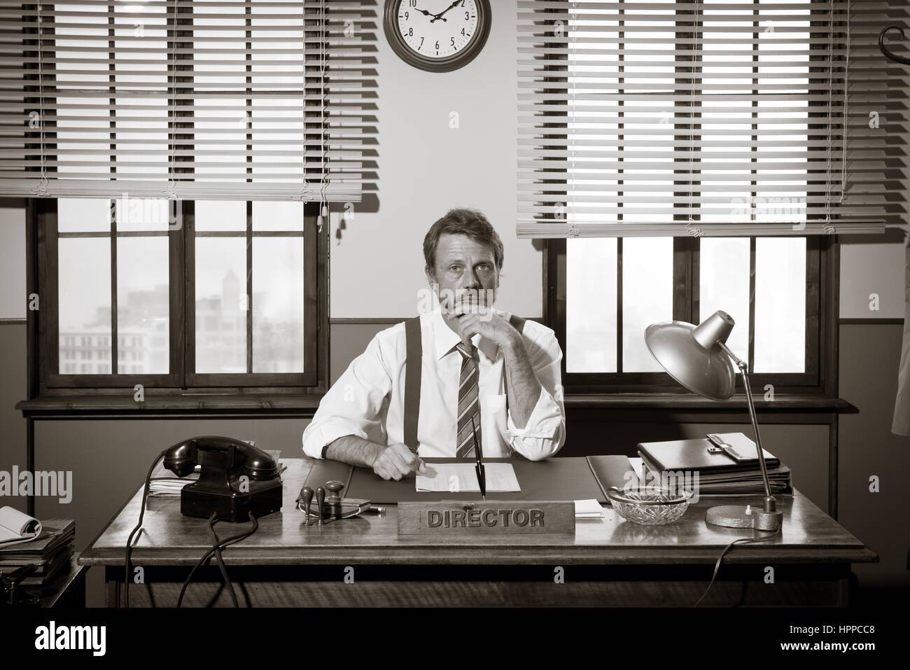 Vintage director working at office desk and looking at camera Stock ...
