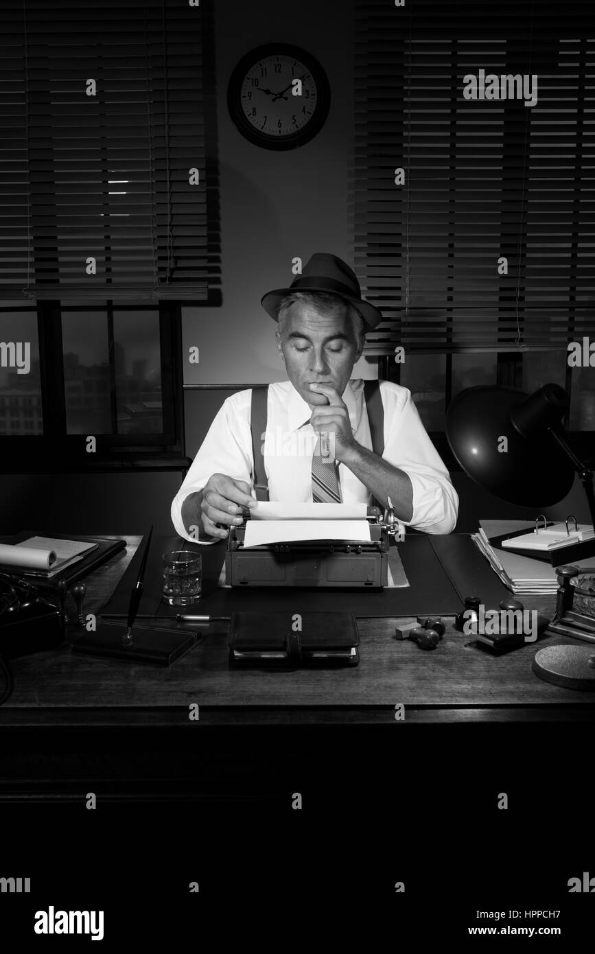 Professional handsome reporter working at office desk, 1950s style ...
