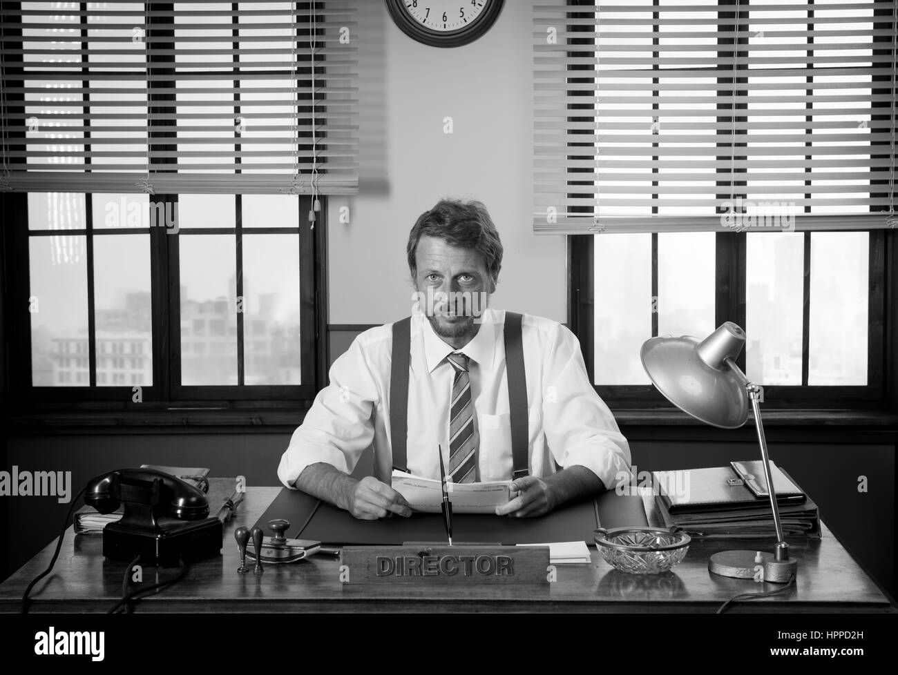 Vintage director working at office desk and looking at camera Stock ...