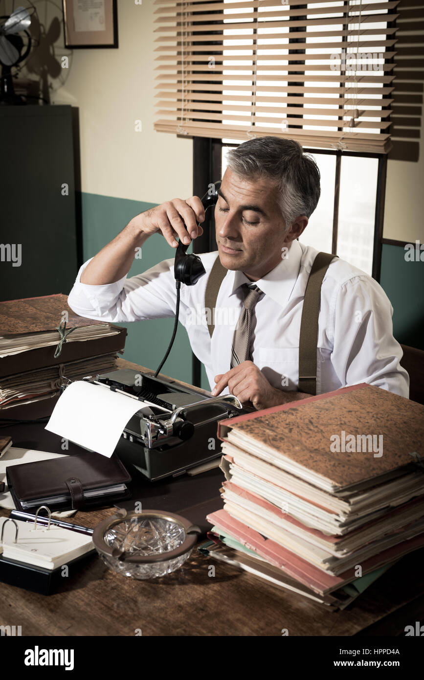 Vintage professional journalist on the phone working at office desk ...
