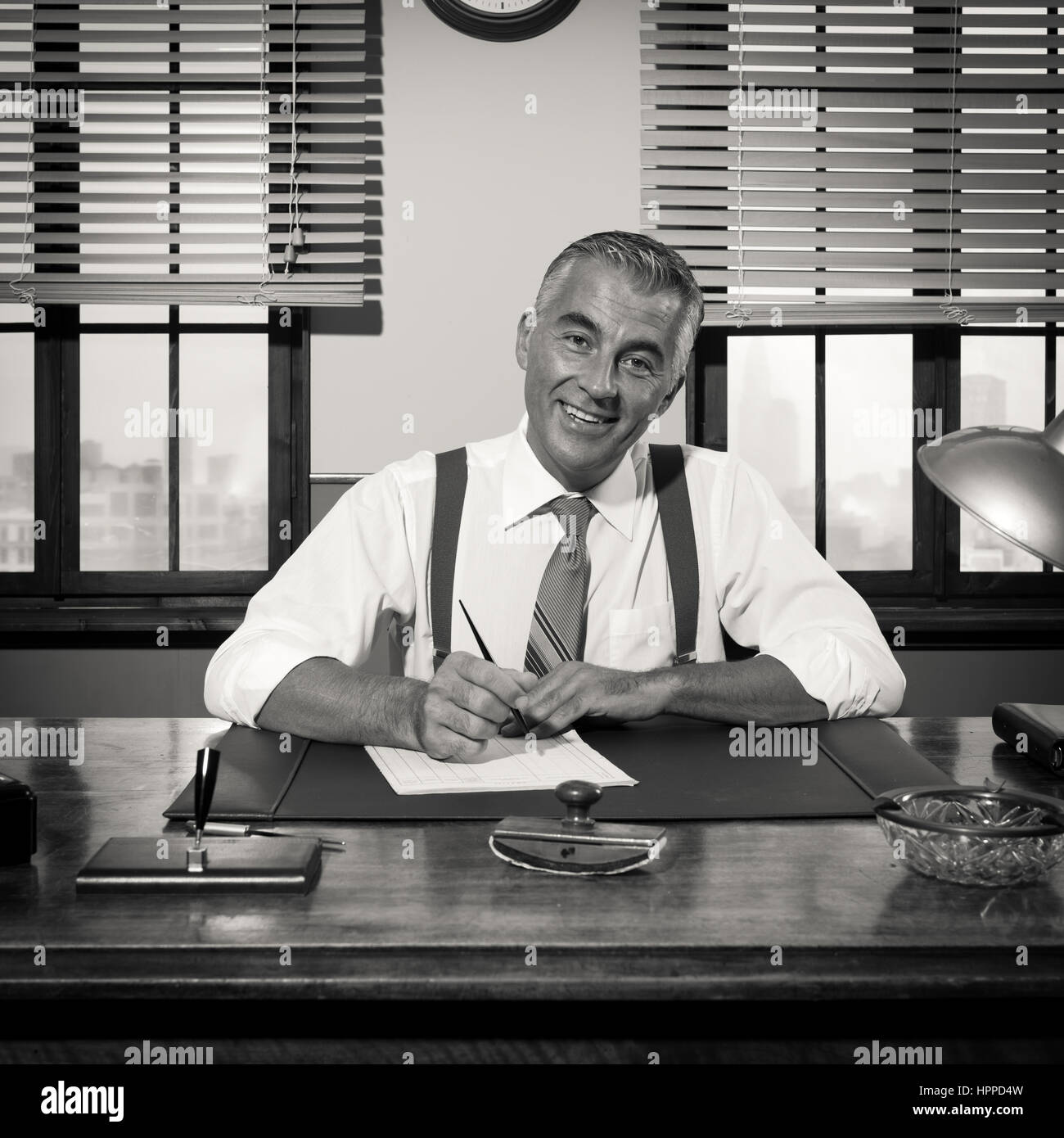 Director at desk signing a document, vintage style office Stock Photo ...