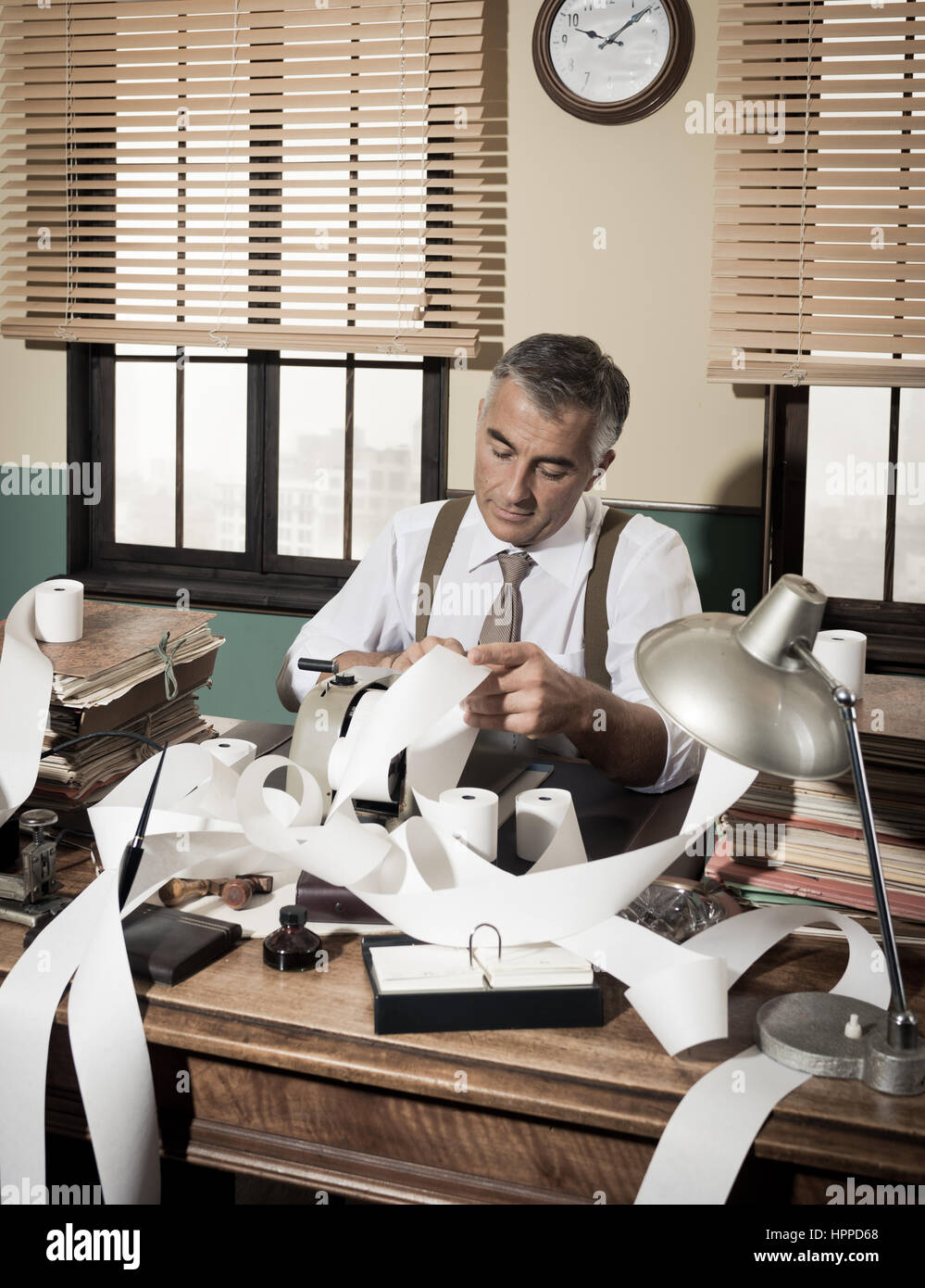 Busy vintage accountant with adding machine surrounded by cash register ...