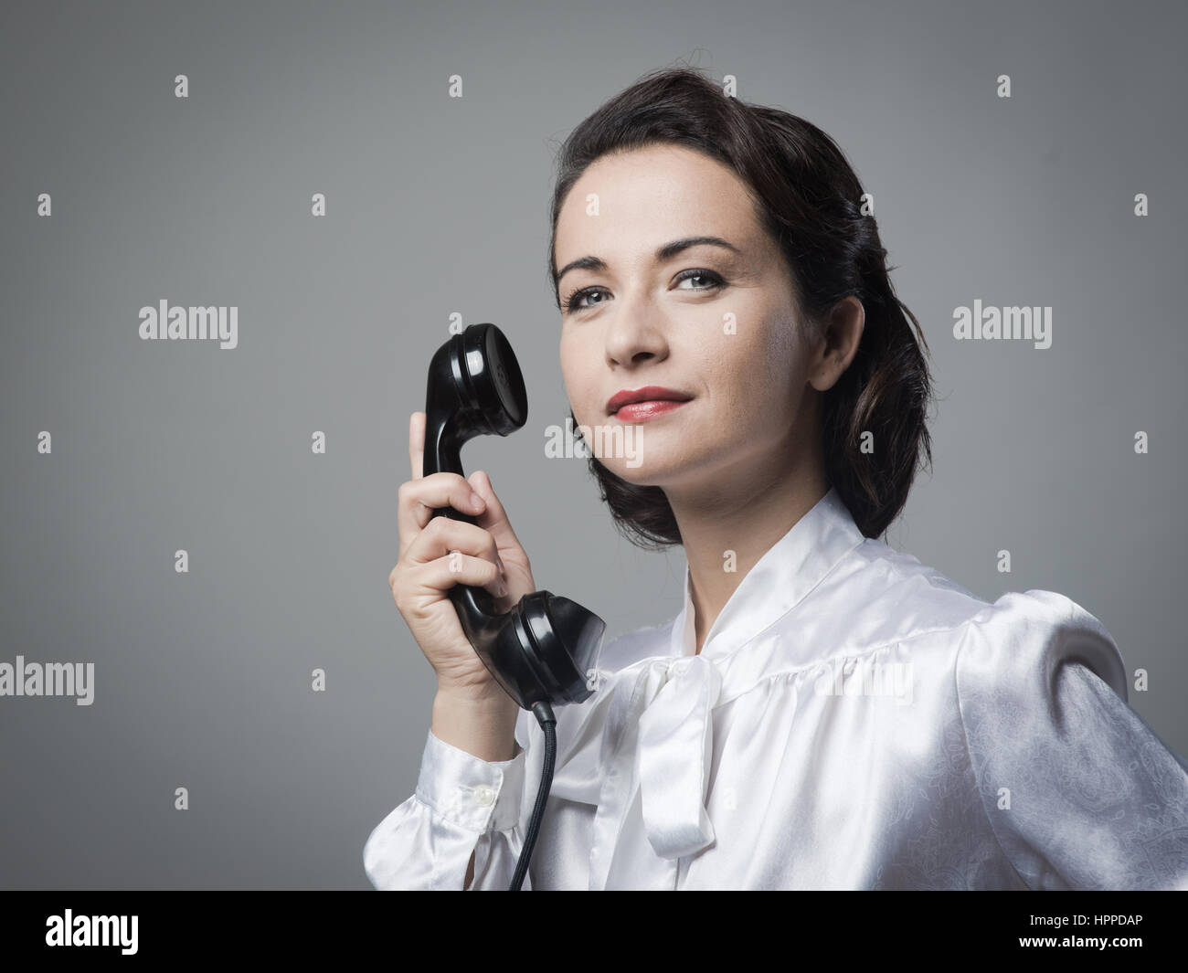 Attractive elegant vintage secretary having a phone call and smiling ...