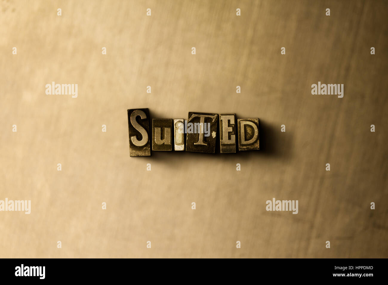 SUITED - close-up of grungy vintage typeset word on metal backdrop ...
