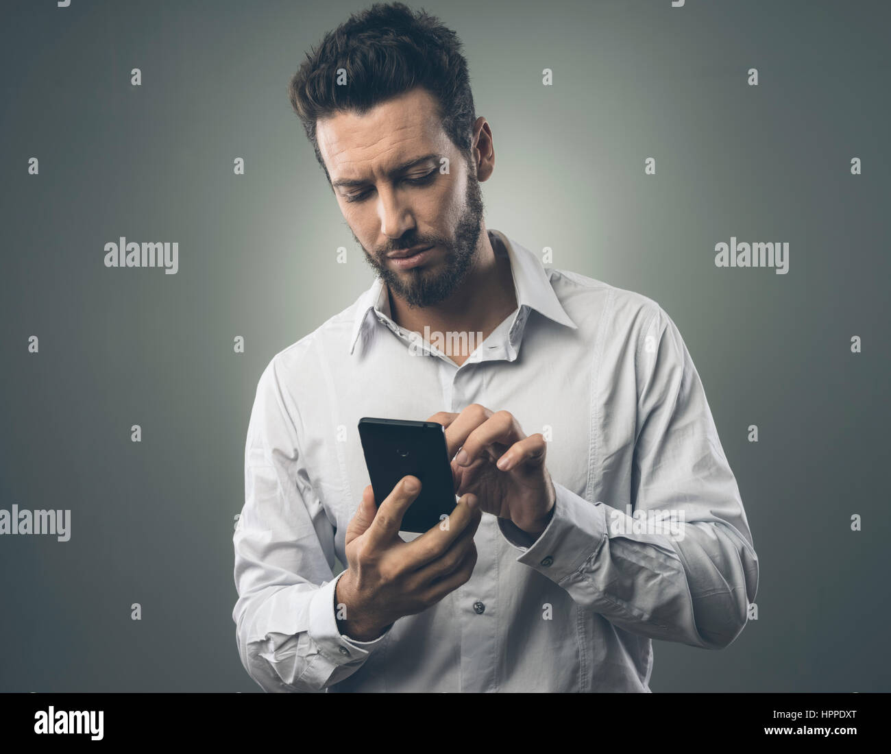 Young confident man texting with his mobile phone Stock Photo - Alamy