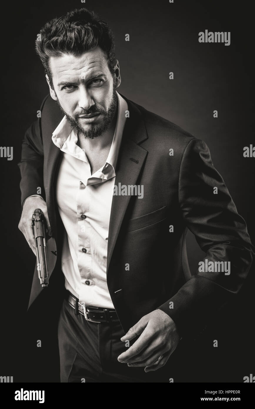 Cool man pulling out quickly his gun and looking at camera Stock Photo ...