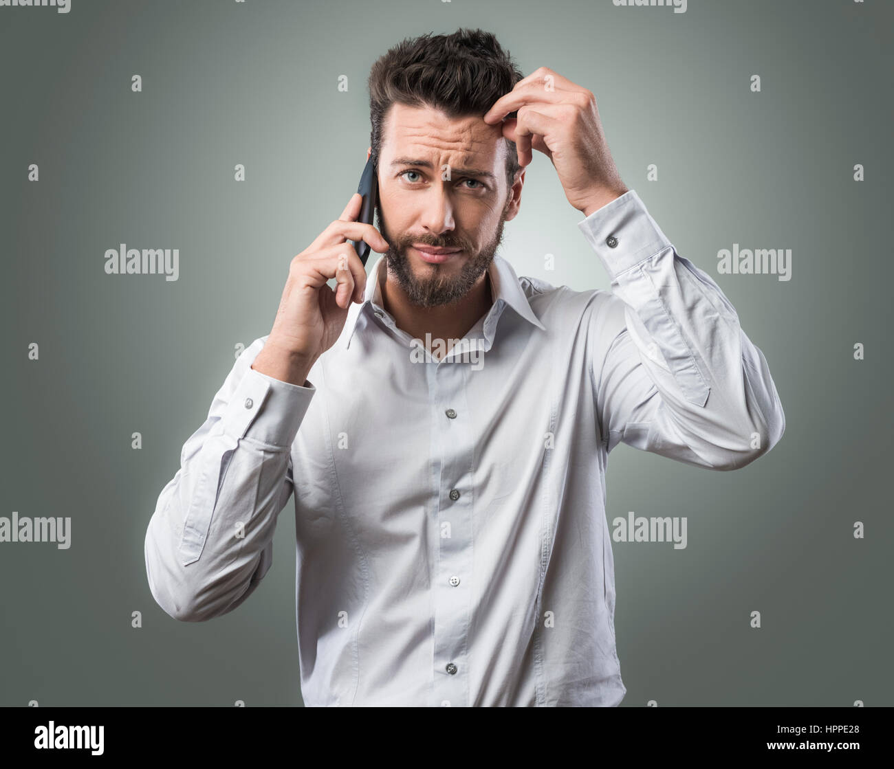 Disappointed confused young man on the phone having a call Stock Photo ...