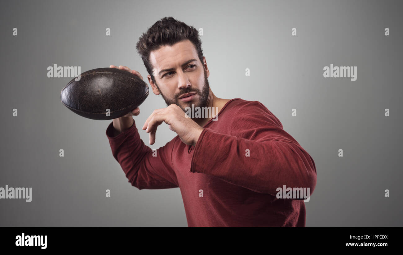 Handsome confident football player in red t-shirt launching ball Stock ...