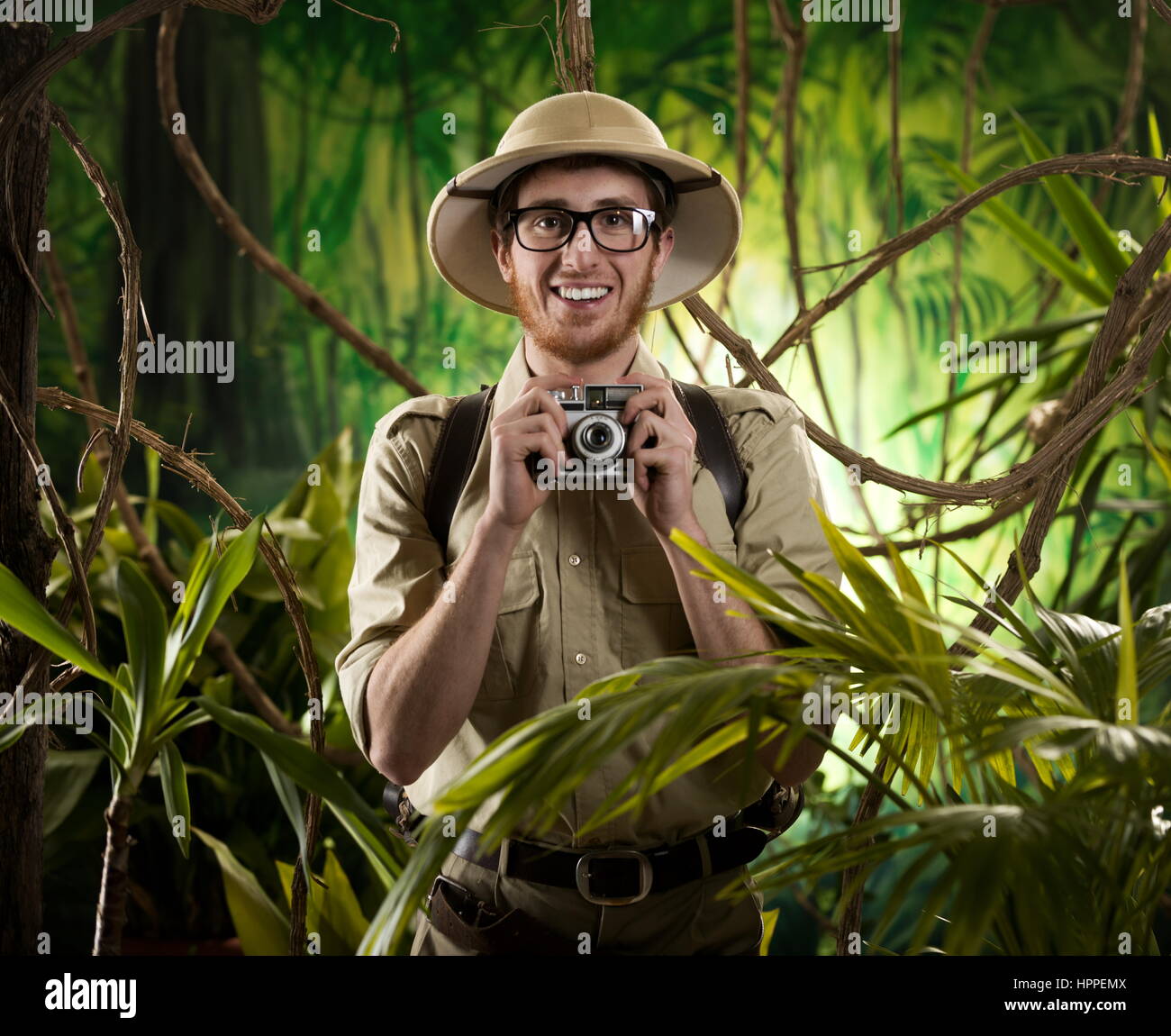 Young explorer in the jungle taking pictures with vintage camera Stock ...