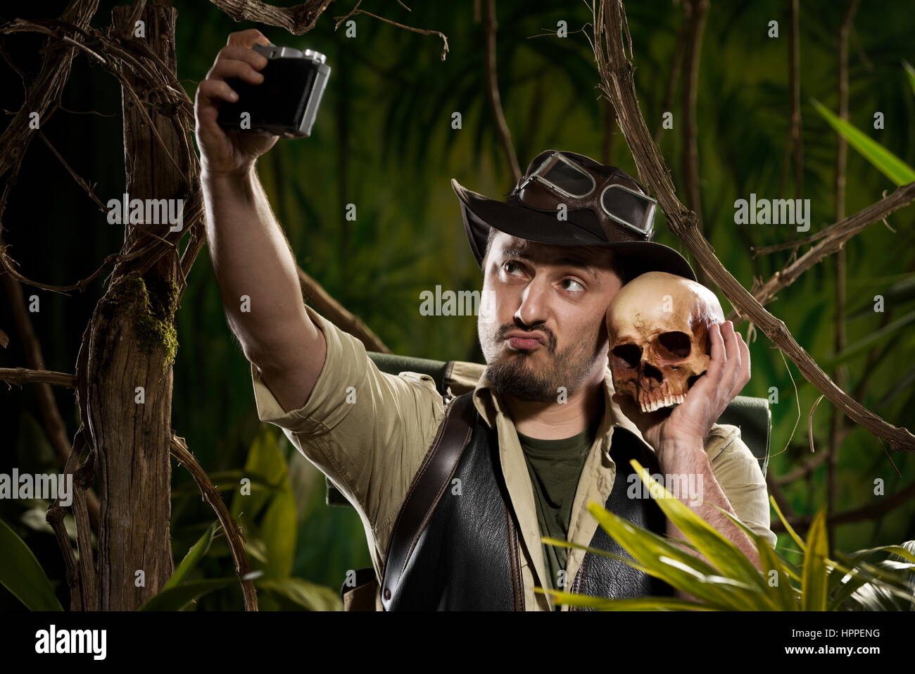 Young adventurer taking a self portrait with a skull in the jungle ...