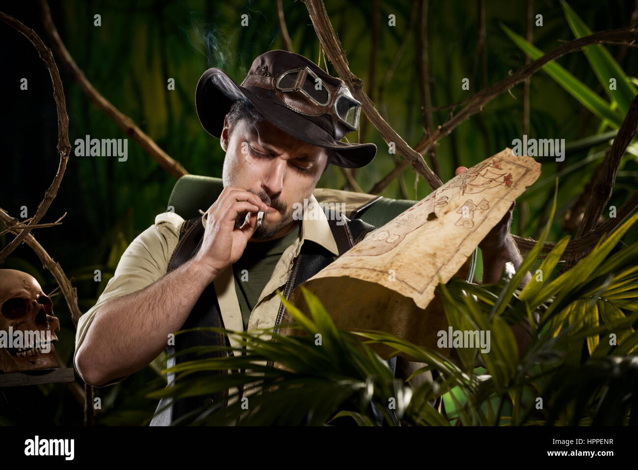 Lost explorer in the jungle holding an old map and smoking a cigarette ...