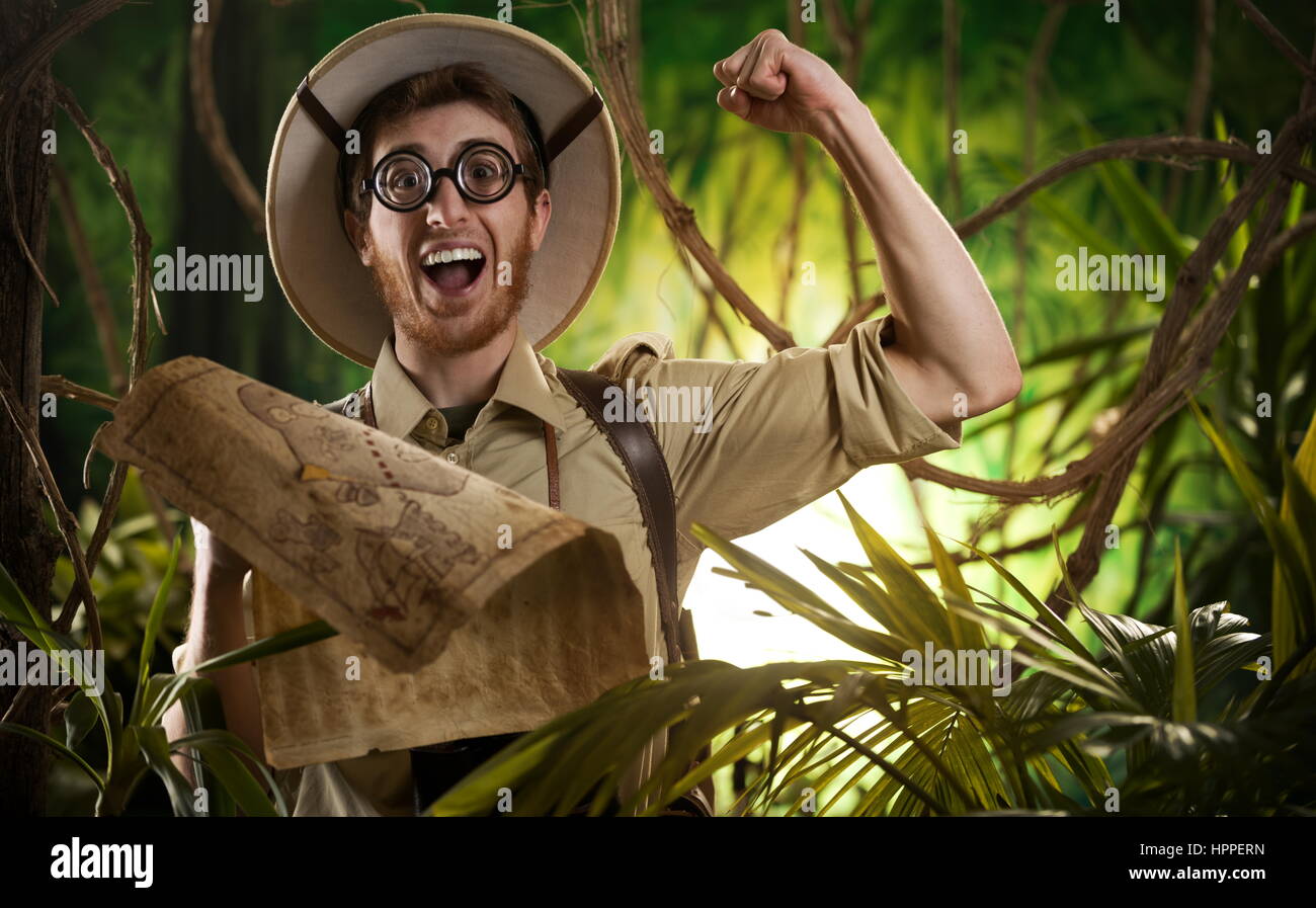 Young smiling explorer in the jungle with thick glasses and fist raised ...