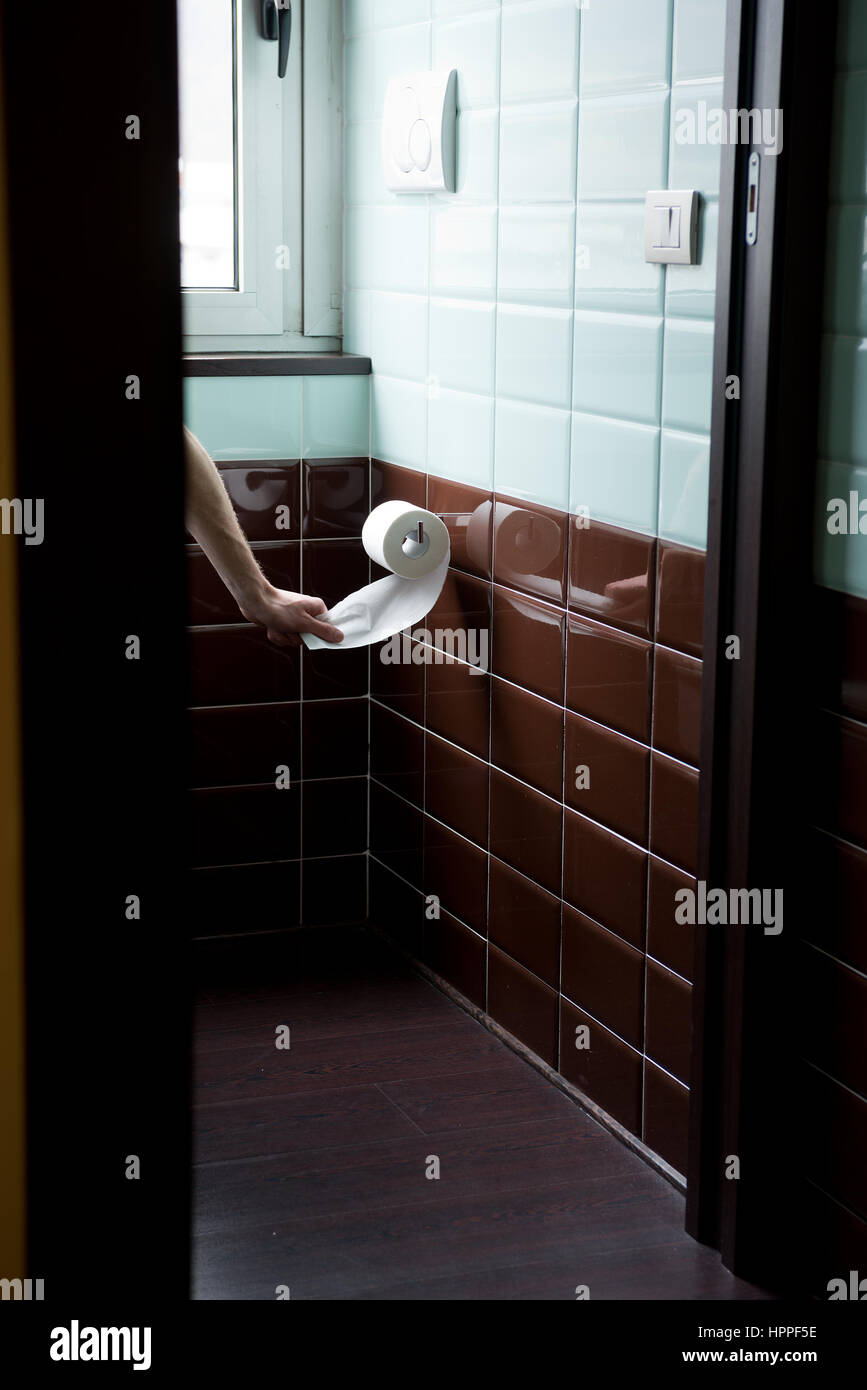 Hidden man using toilet paper in the restroom for cleansing Stock Photo ...