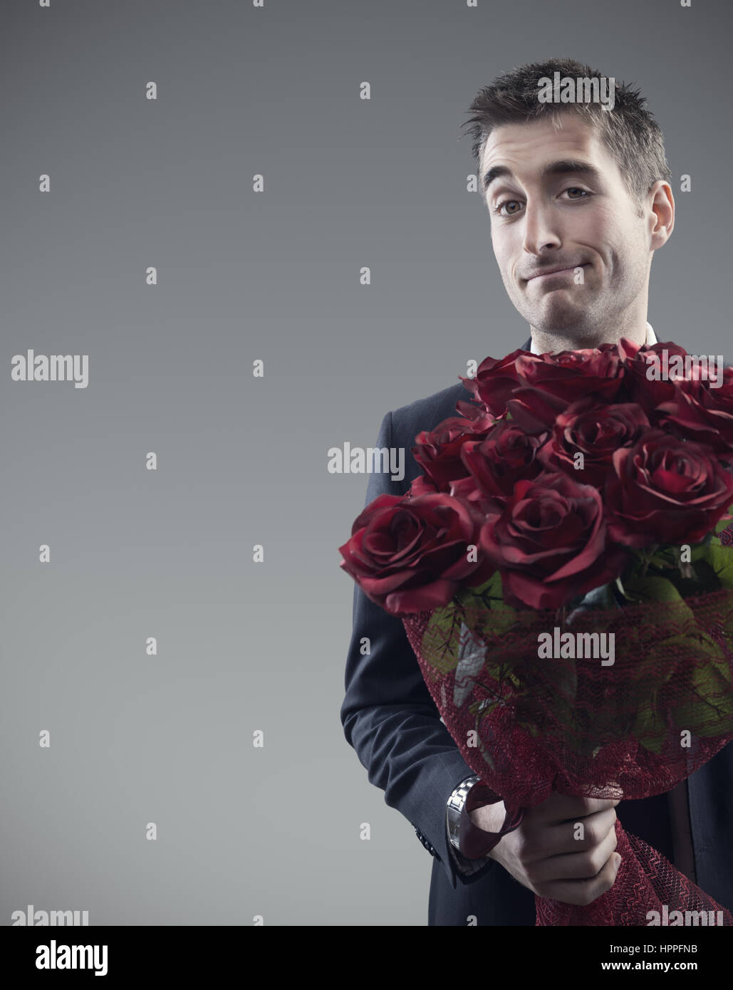Man holding out large bouquet of red roses Stock Photo - Alamy