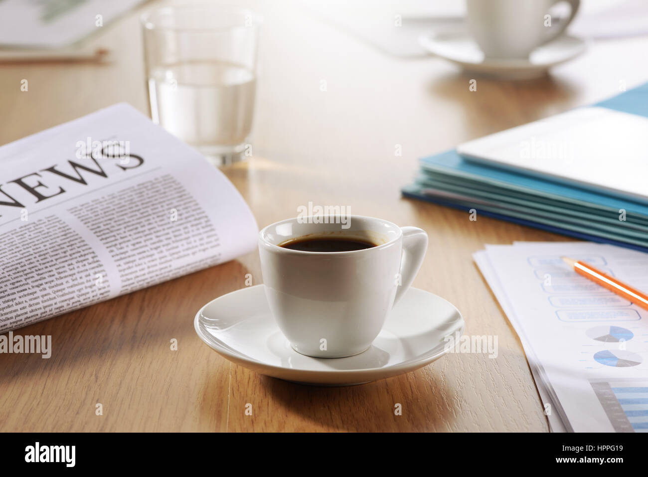 Business Office scene, Coffee, newspaper, water glass on meeting desk ...