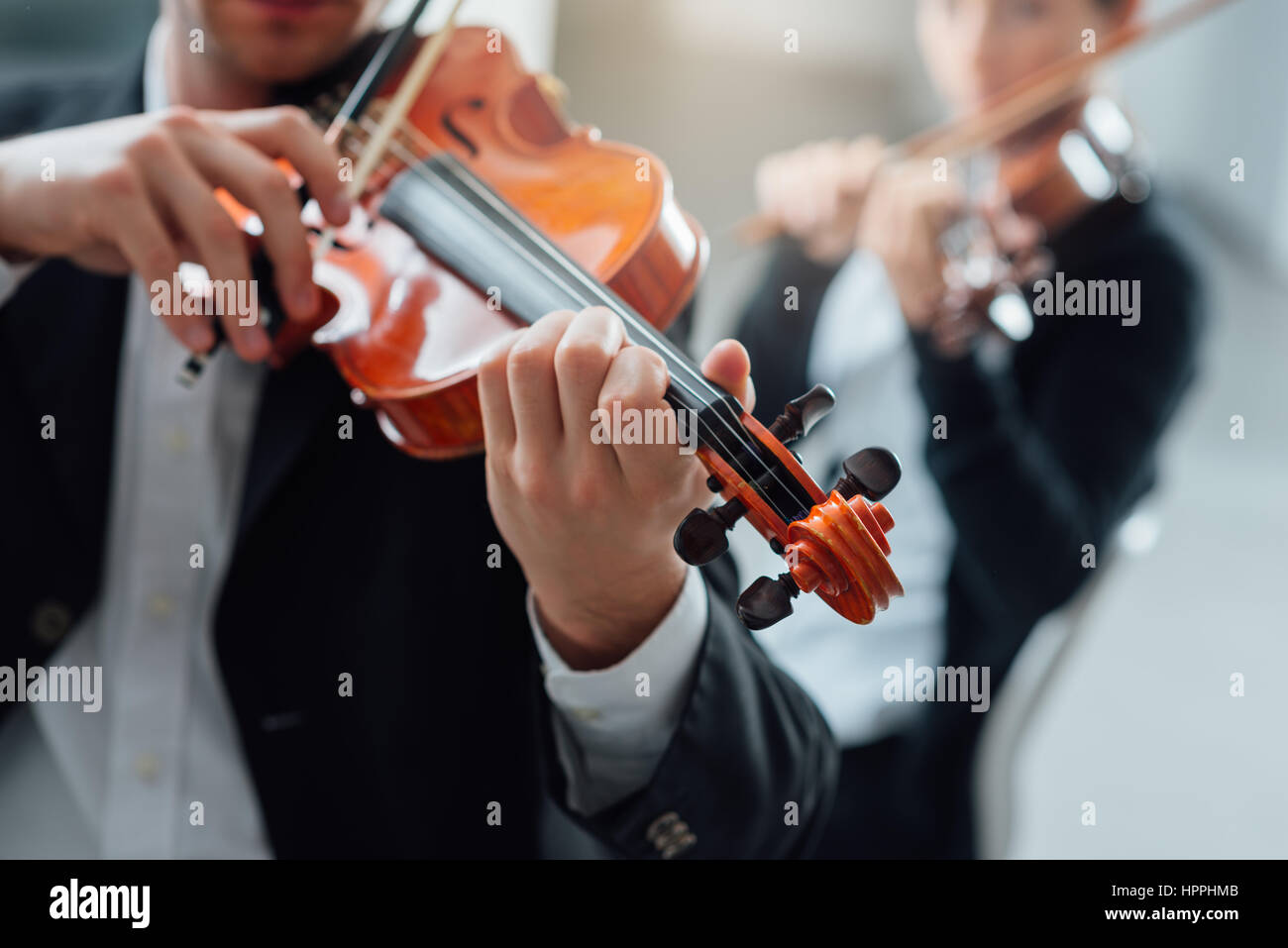 Two violinists performing together hands close up, classical music ...