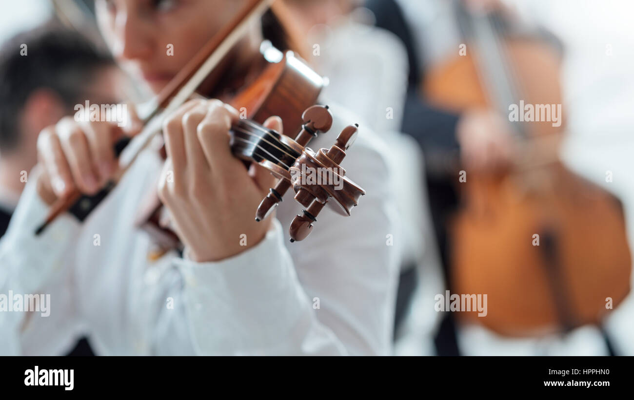 Talented female violinist playing her violin with classical music ...
