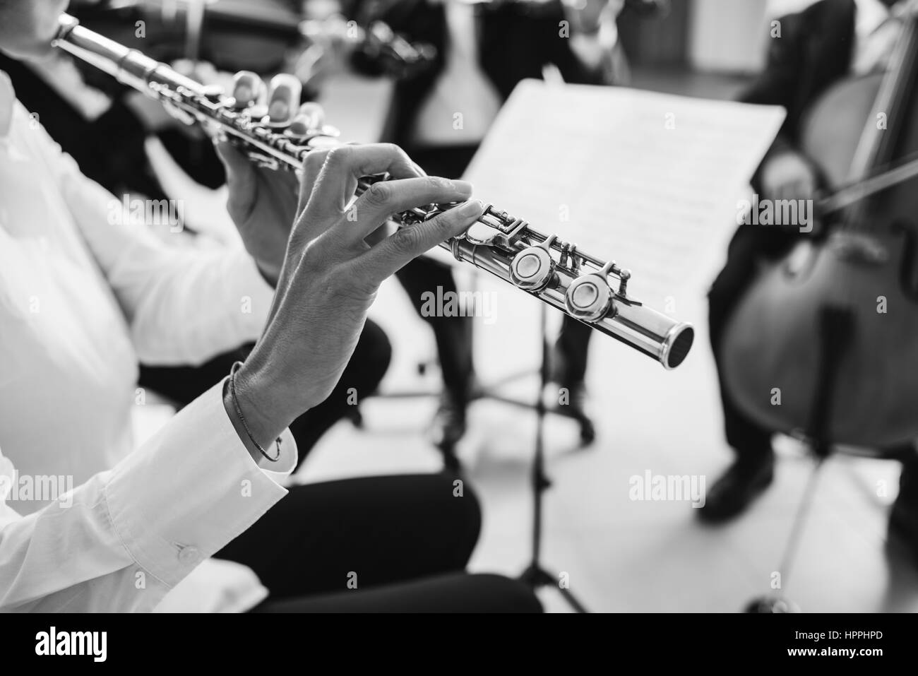 Professional female flustist playing her instrument on stage with ...
