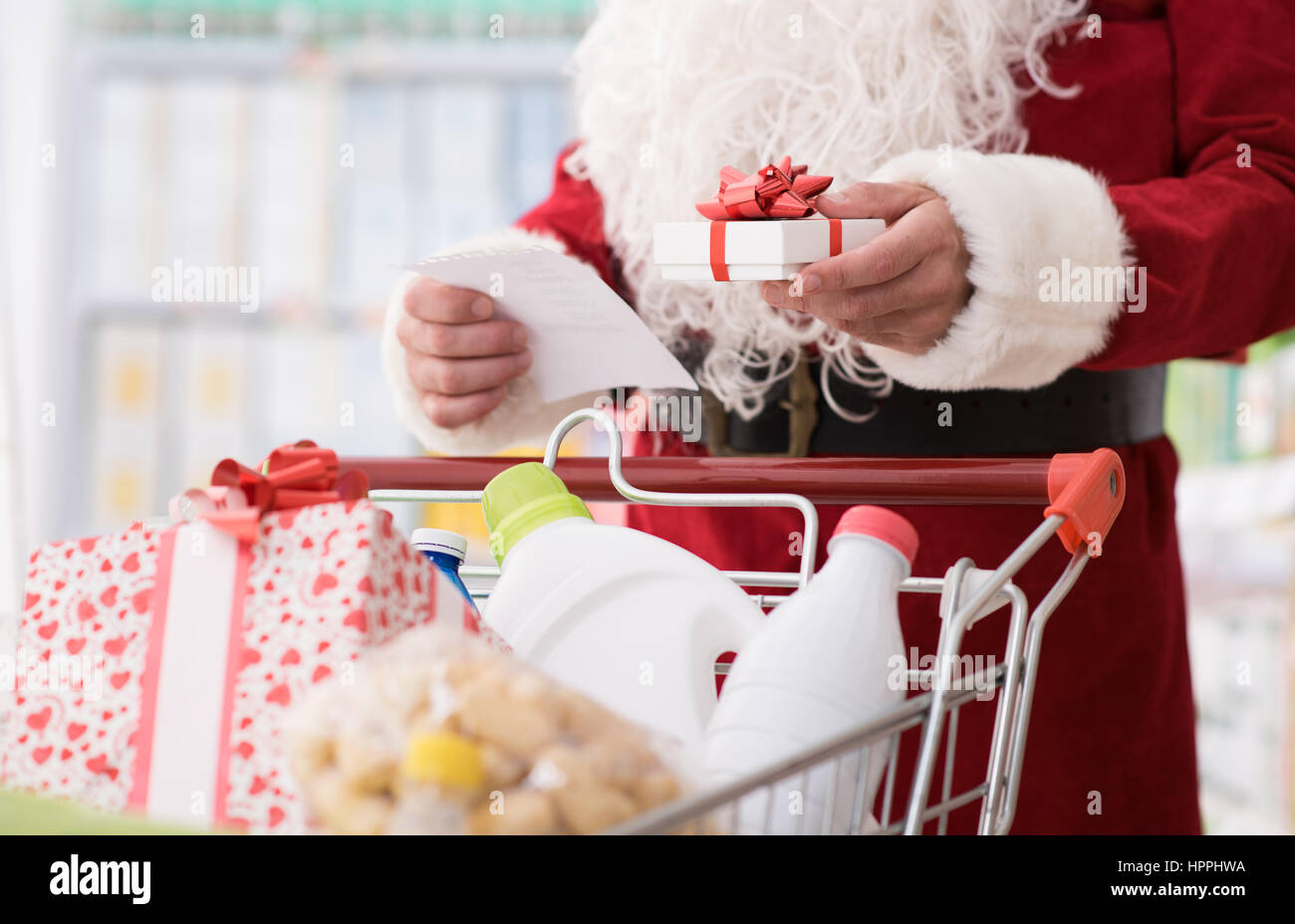 Santa Claus doing grocery shopping at the supermarket, he is pushing a ...