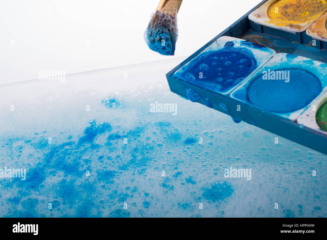 Watercolor paint dissolving in water covered with foam Stock Photo - Alamy