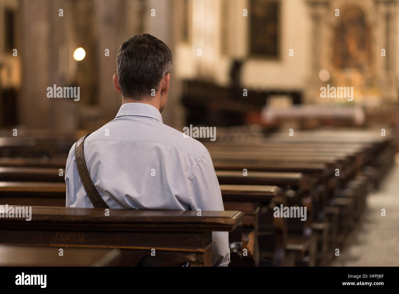 Man sitting in a pew at Church and meditating, faith and religion ...