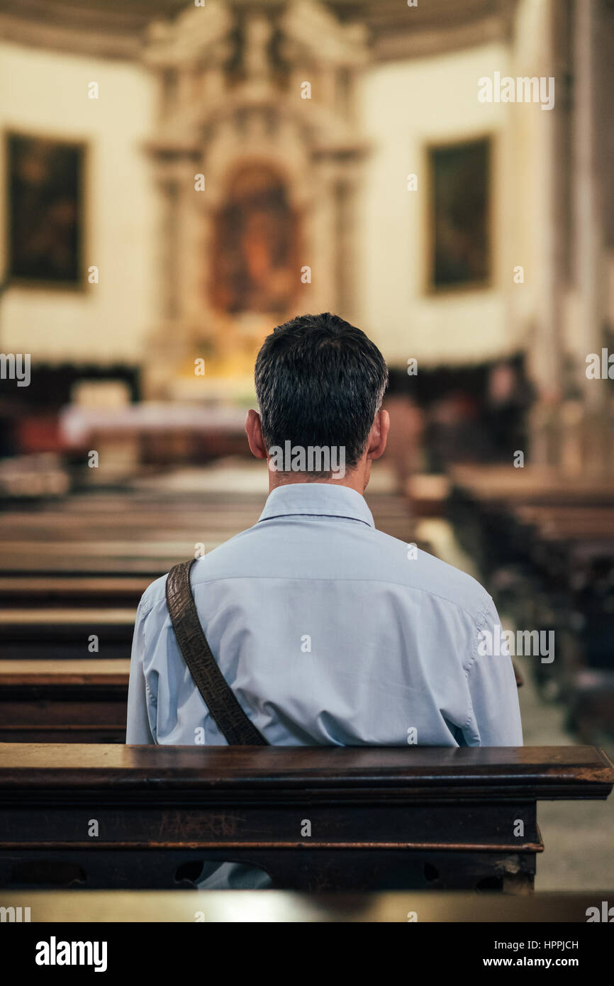 Man sitting in a pew at Church and meditating, faith and religion ...