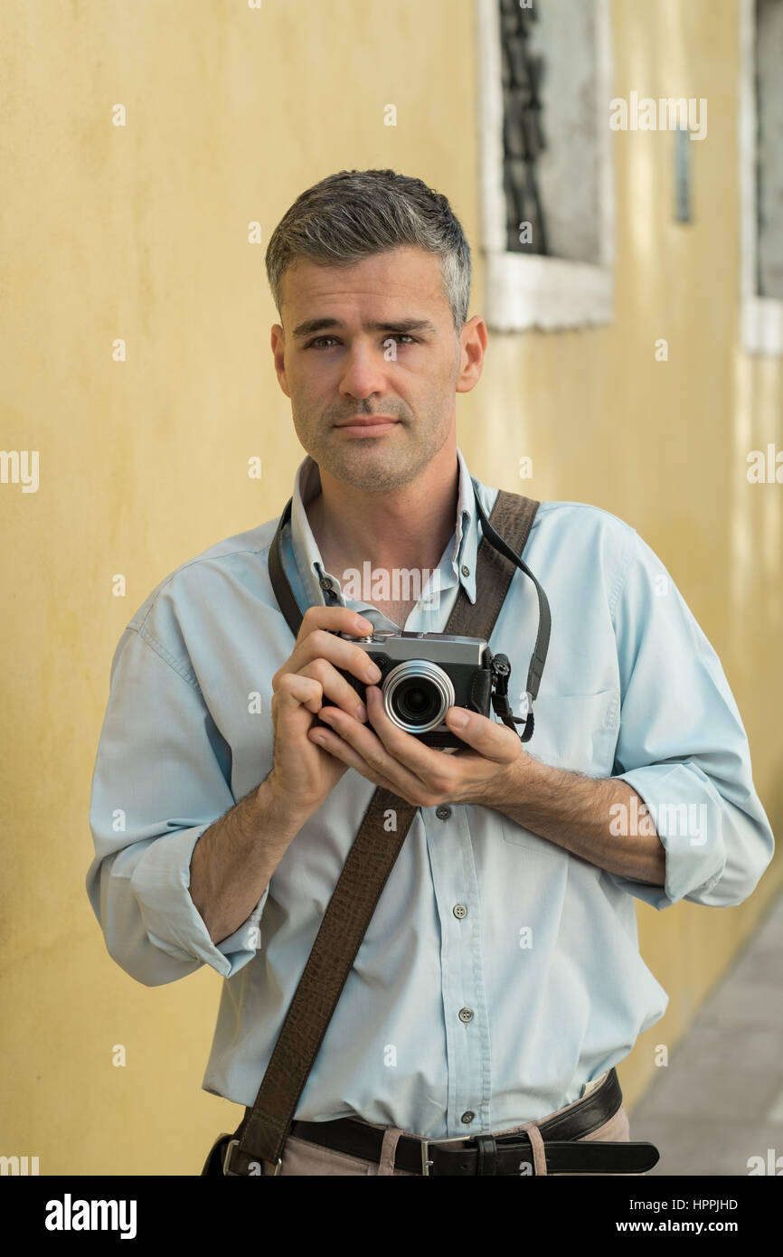 Confident photographer exploring a city and taking pictures with a ...