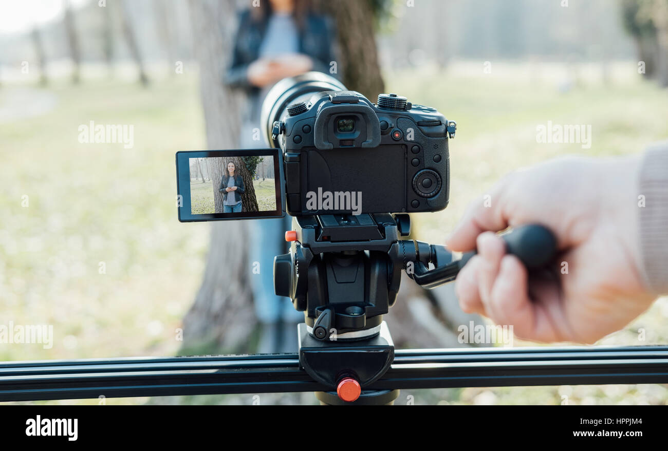 Video shooting at the park: video camera and operator hand on ...