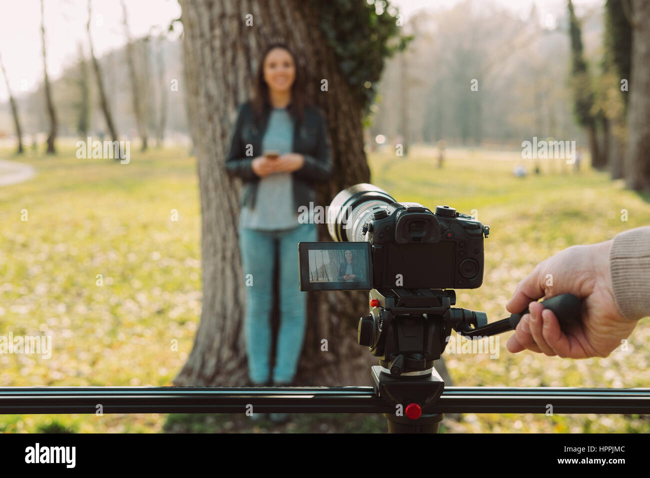 Video shooting at the park: video camera and operator hand on ...