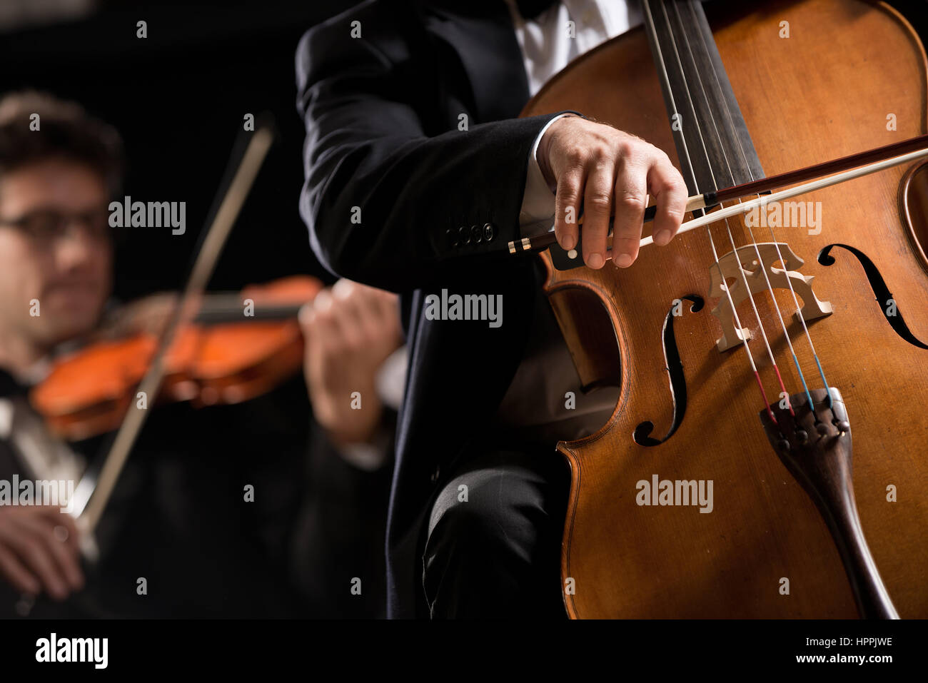 Cello professional player with symphony orchestra performing in concert ...